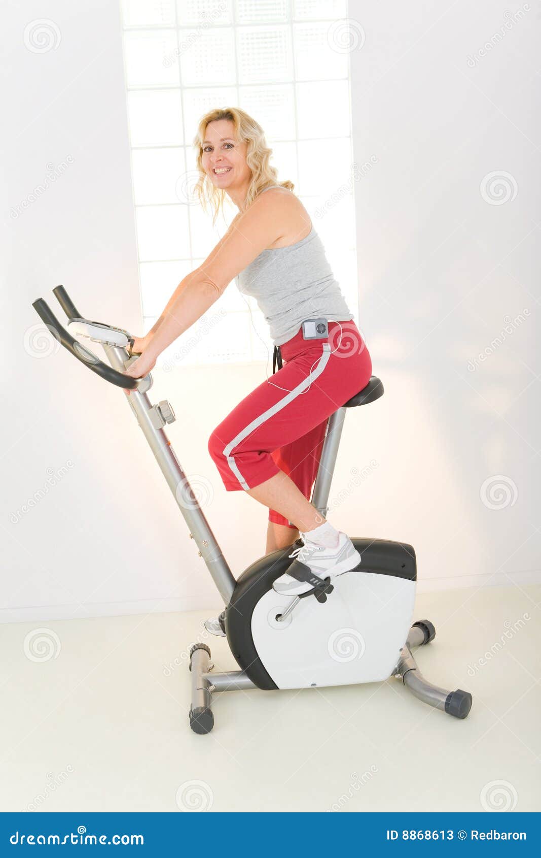 Woman on exercise bike stock image. Image of bicycle, healthclub - 8868613