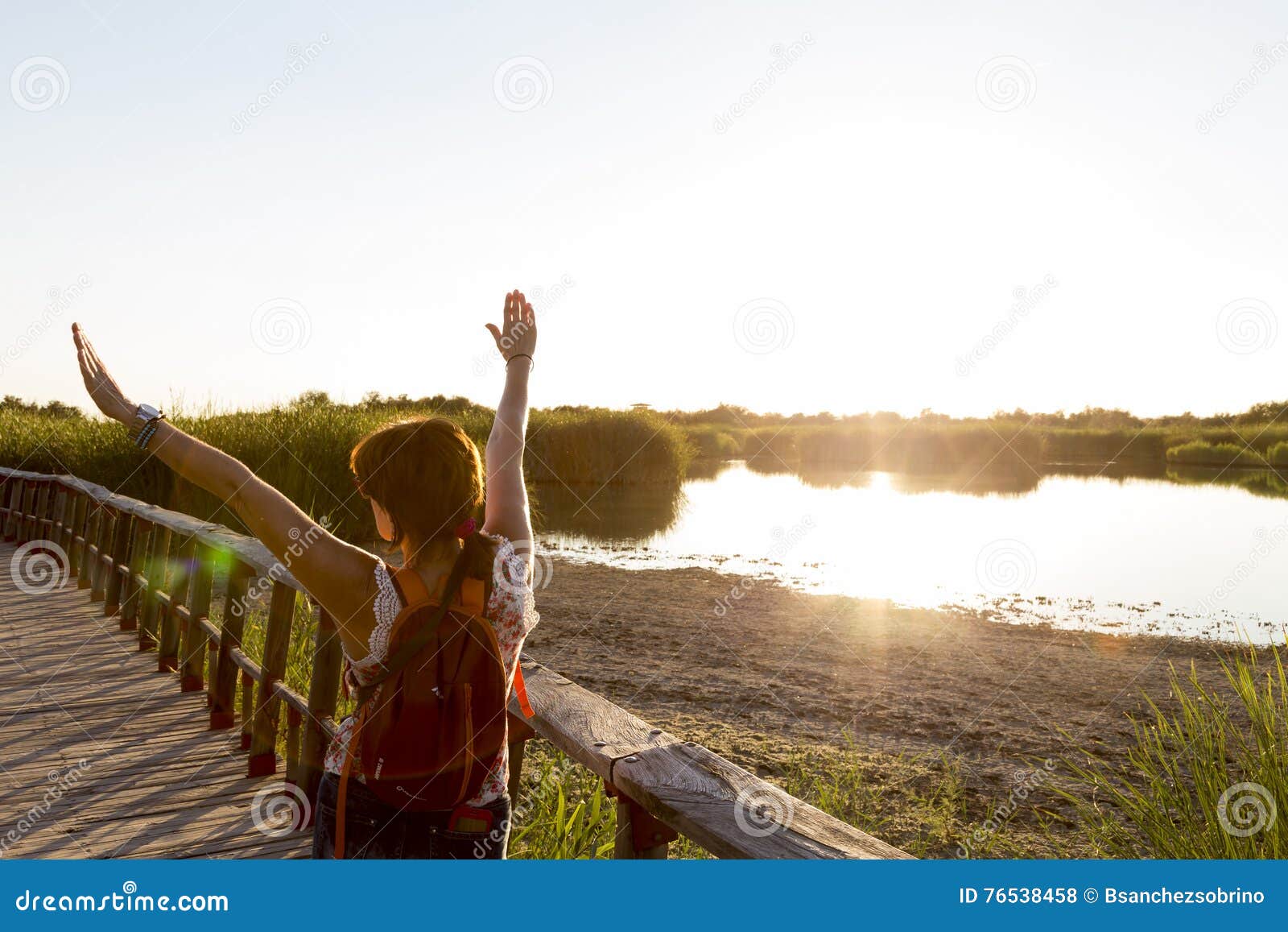 Woman facing the sunset stock photo. Image of backpack - 76538458