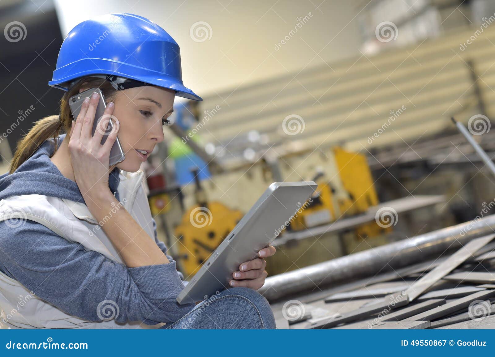 Woman in Factory Talking on a Smartphone and Using Tablet Stock Image ...