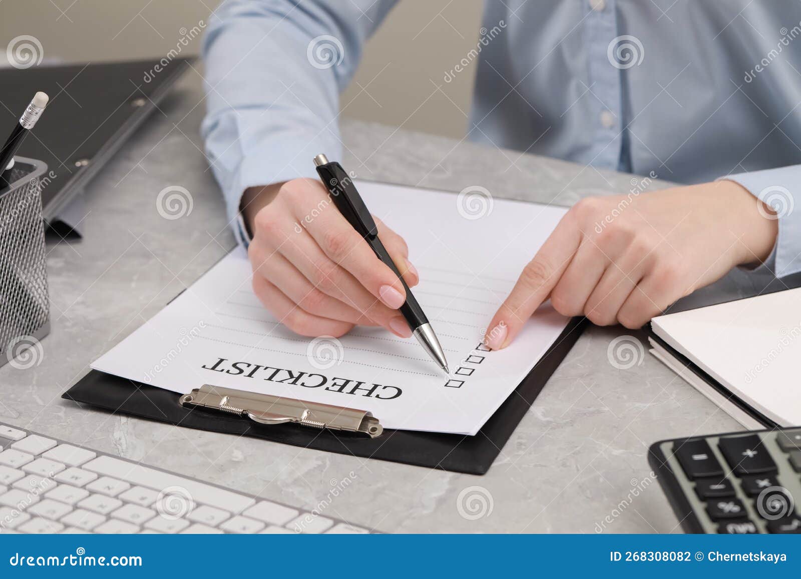 Woman Filling Checklist at Grey Marble Table, Closeup Stock Photo ...