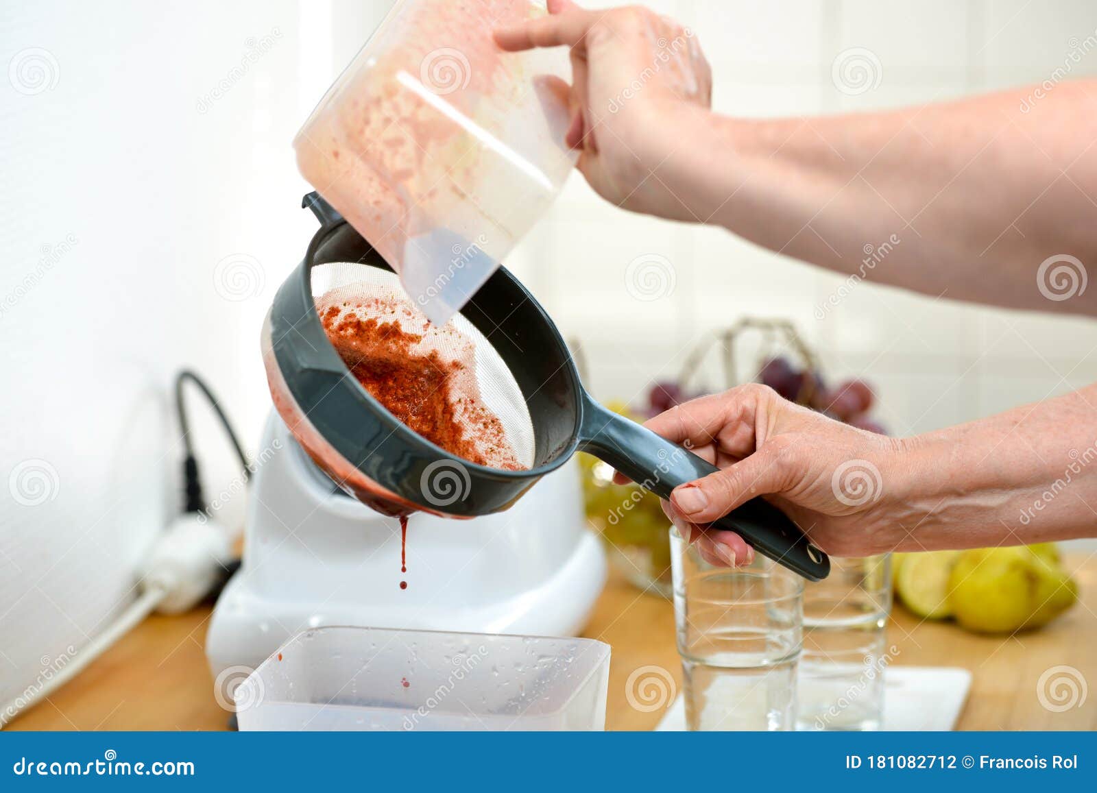 Woman Filtering Dark Red Fruits and Vegetables Juice with a Sieve Stock ...