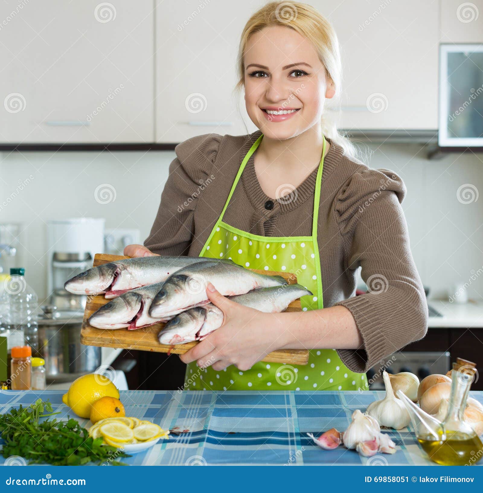 Woman with fish stock image. Image of branzini, branzino - 69858051