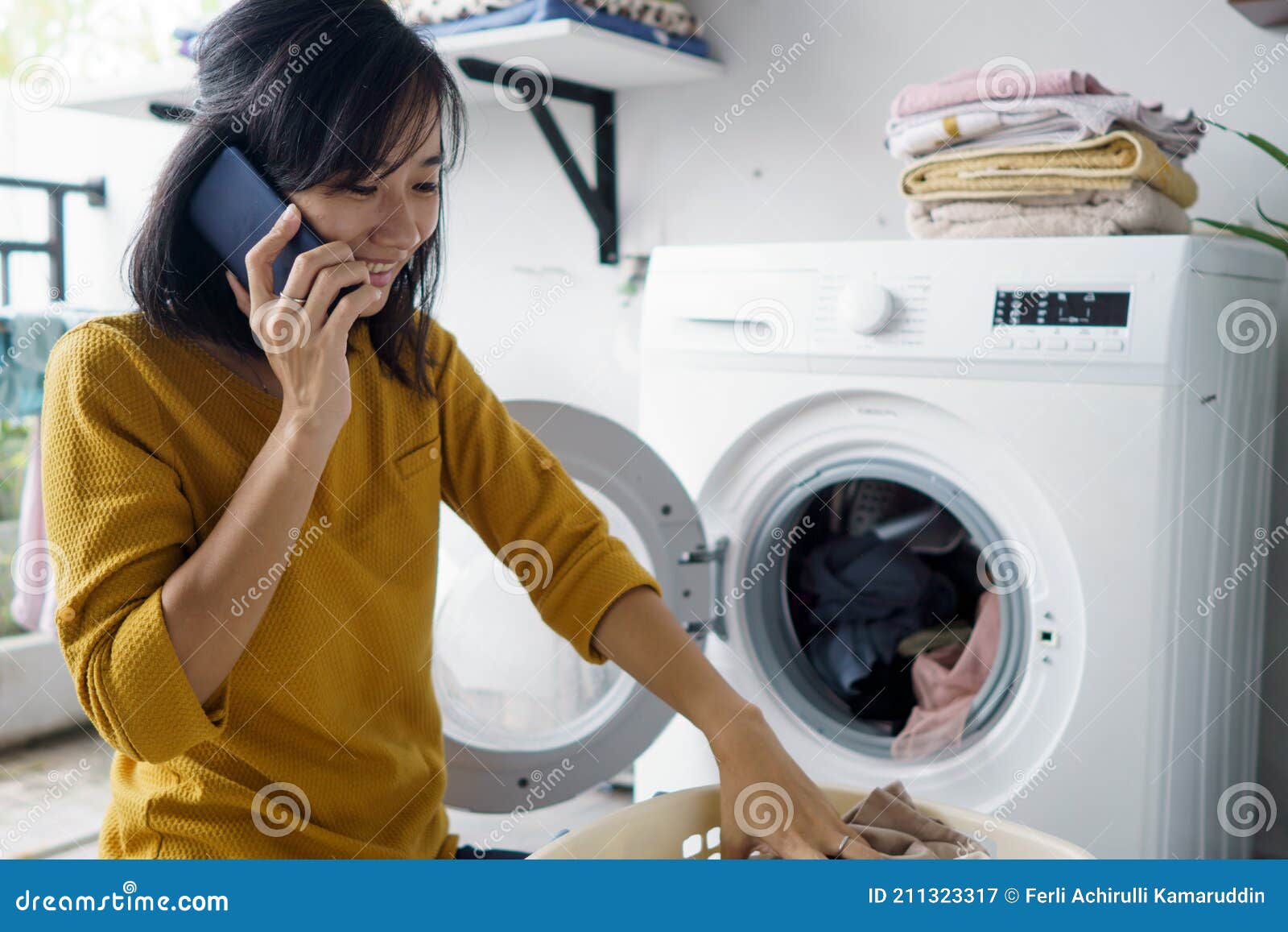 Woman in Front of the Washing Machine Using Phone Stock Image - Image ...
