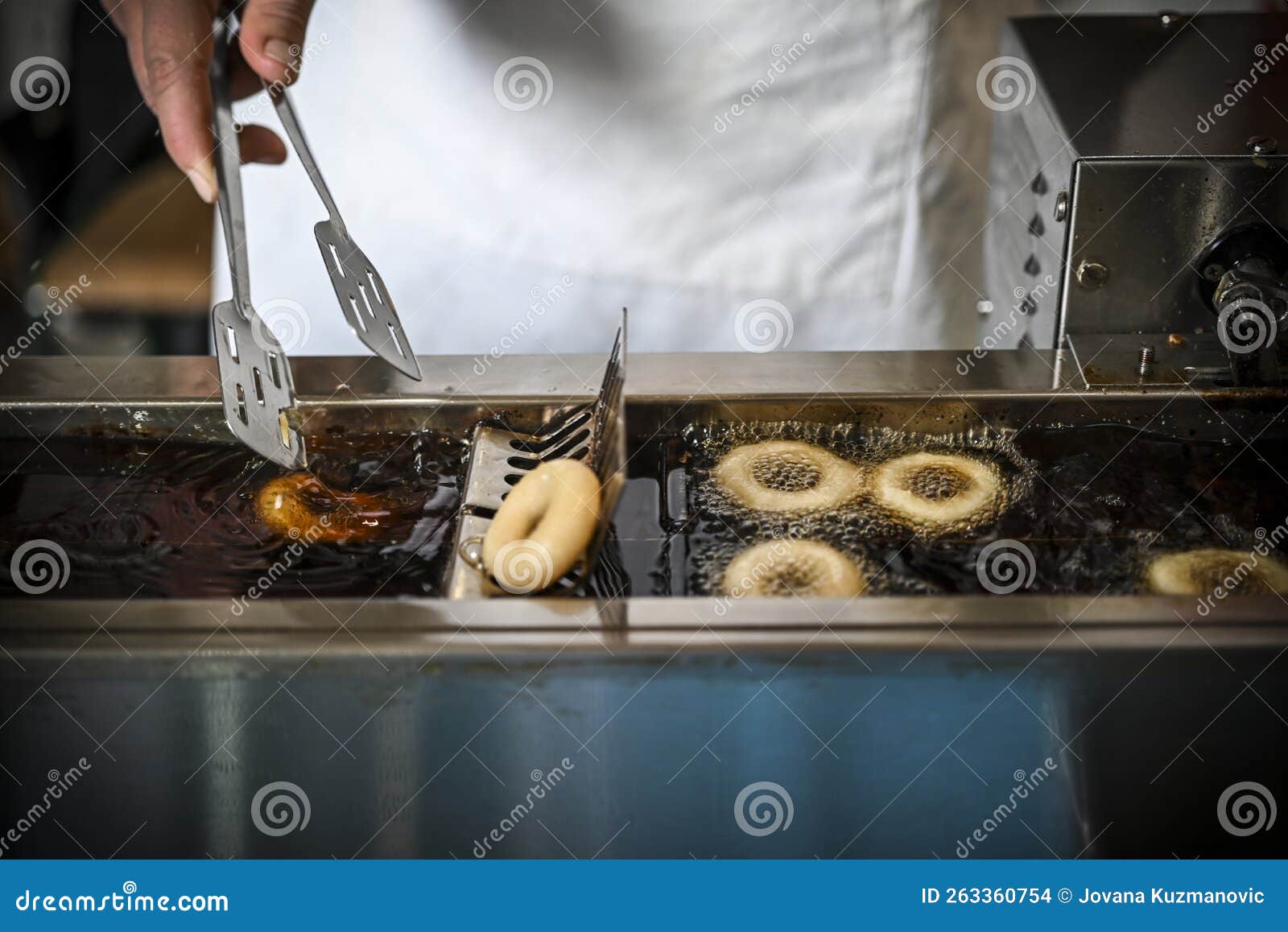 A Woman Frying Donuts stock photo. Image of greasy, delicious - 263360754