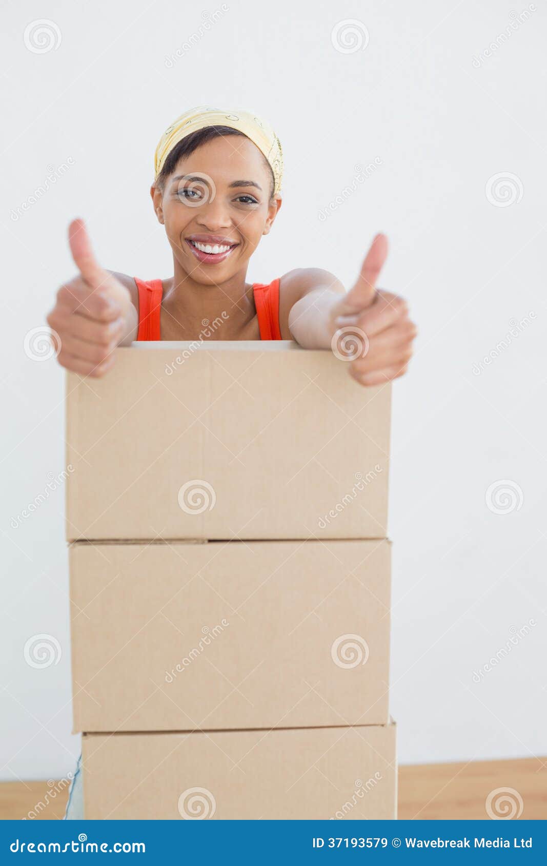 Woman Gesturing Thumbs Up with Stack of Boxes in a New House Stock ...