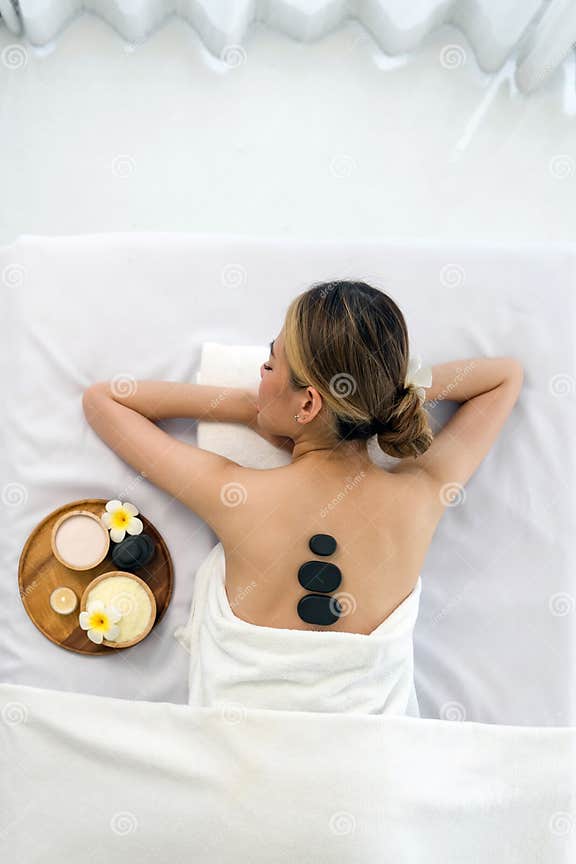 Woman Getting Spa Hot Stones Massage Lying On A Massage Table