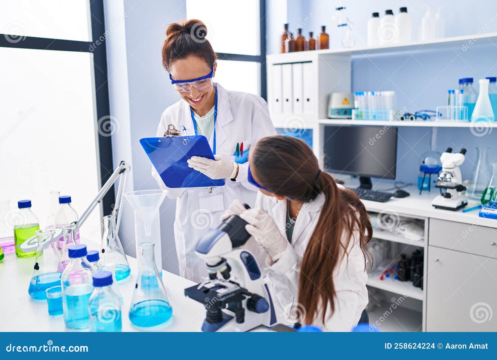 Woman and Girl Wearing Scientist Uniform Using Microscope at Laboratory ...