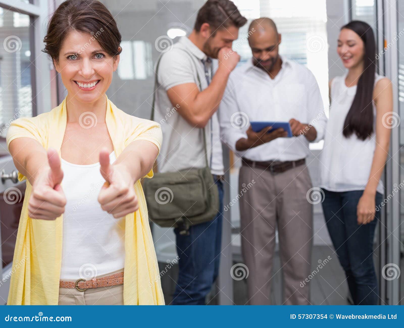 Woman Giving Thumbs Up at Camera in Front of Her Colleagues Stock Photo ... Woman Giving Thumbs Up at Camera in Front of Her Colleagues Stock Photo ...