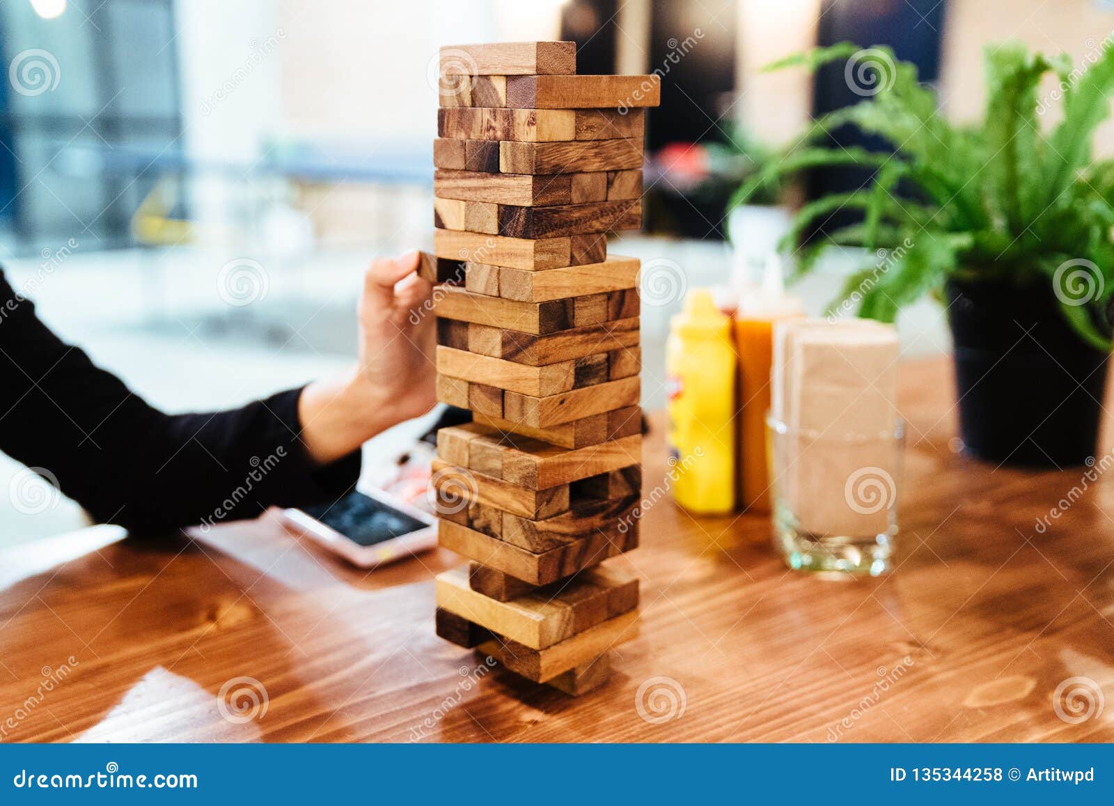 Woman Hand Slowly Pulling Wooden Block from Unstable Jenga Blocks ... Woman Hand Slowly Pulling Wooden Block from Unstable Jenga Blocks ...