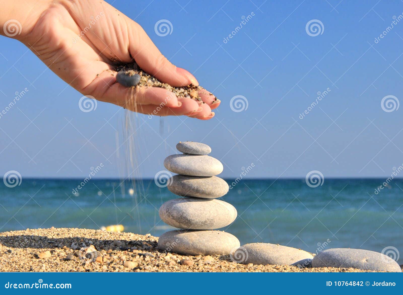 Woman Hand Sprinkles Sand on Pebble Stack Stock Photo - Image of ...