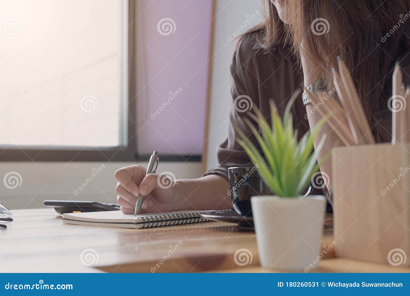Woman Hand Working at a Computer and Writing on a Notepad with a Pen in ...