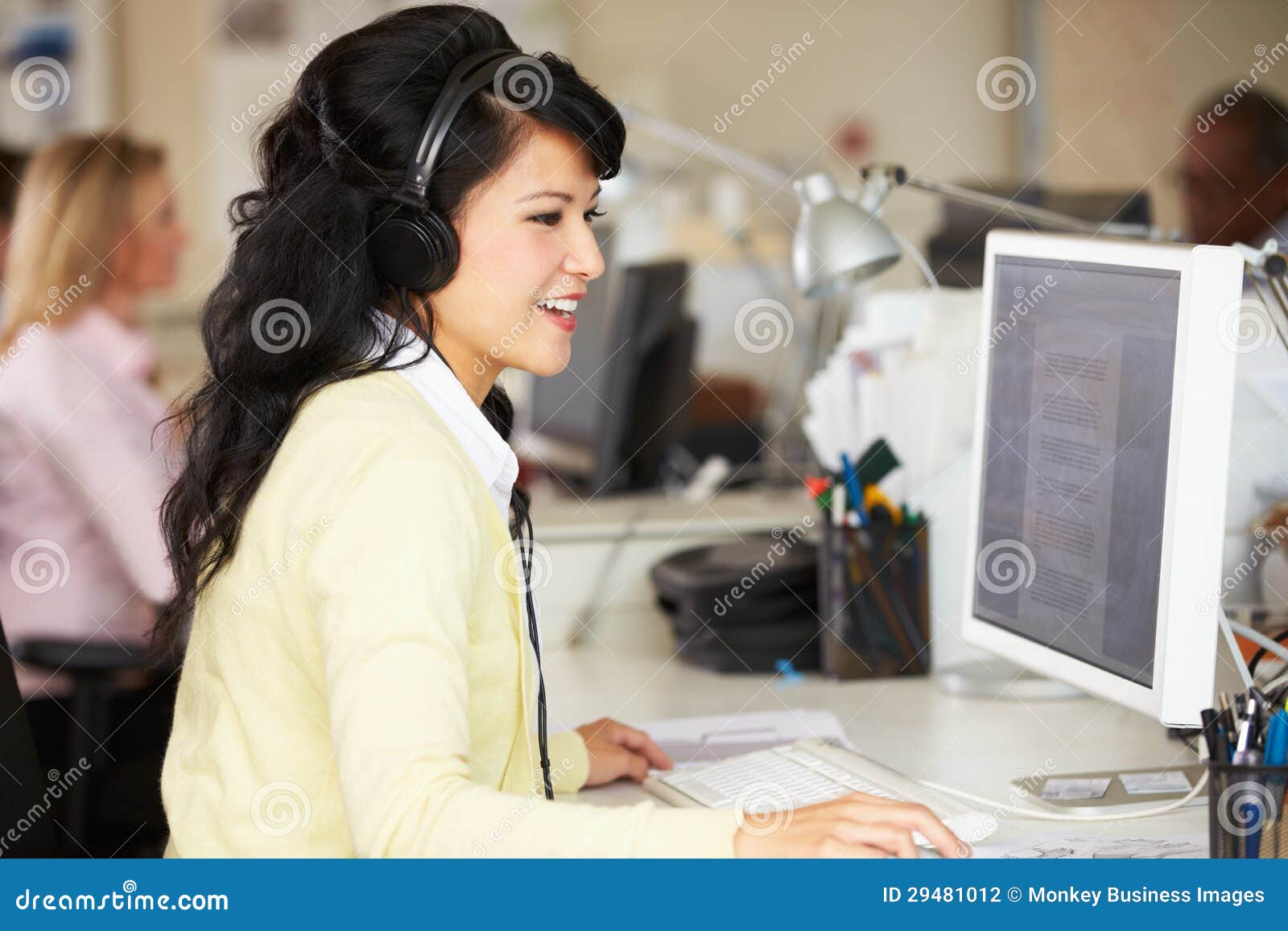 Woman with Headset Working at Desk in Busy Creative Office Stock Photo ...