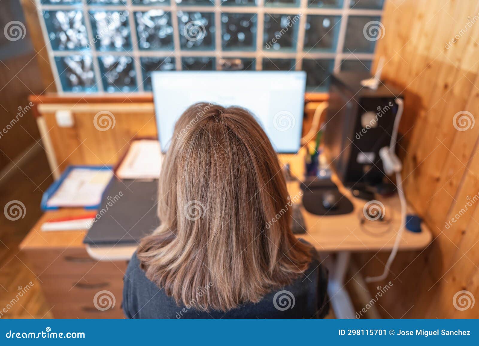 Woman with Her Back Turned Working from Home at Her Workstation with ...