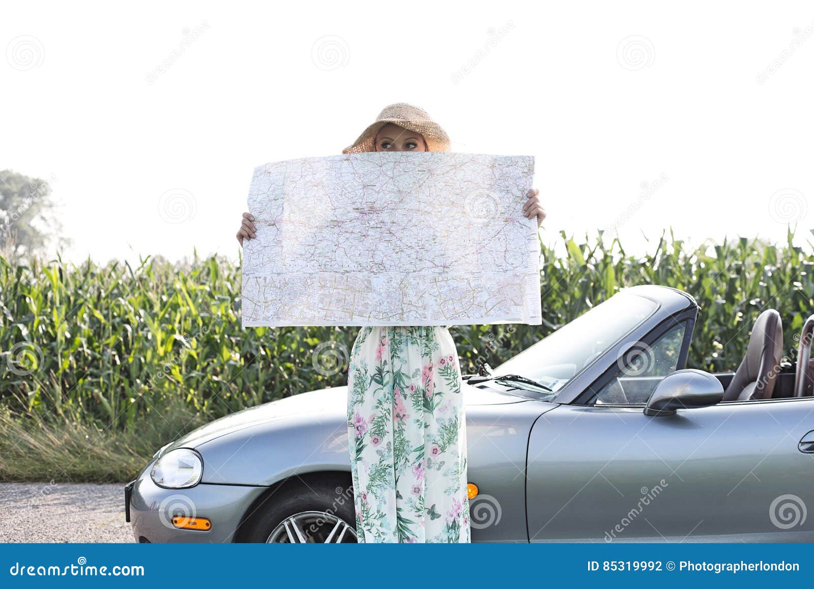 Woman Hiding Face with Map by Convertible Against Clear Sky Stock Photo ...