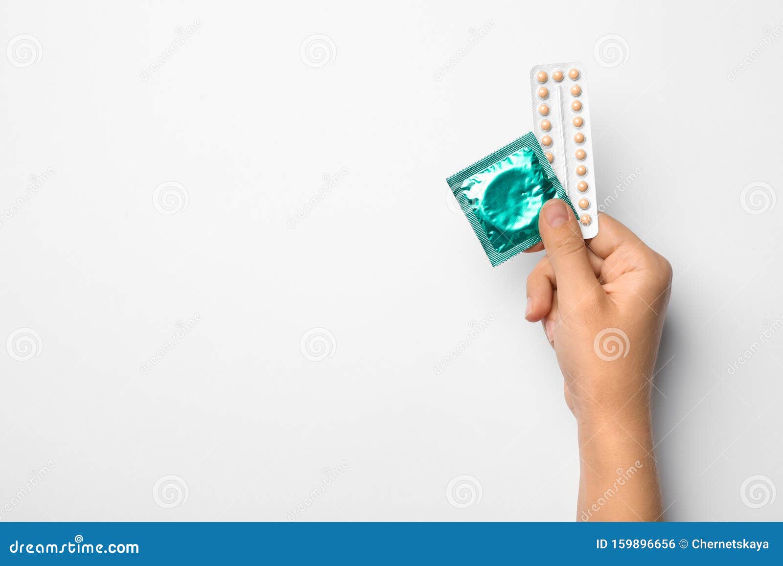 Woman Holding Condom And Birth Control Pills On White Top View Safe