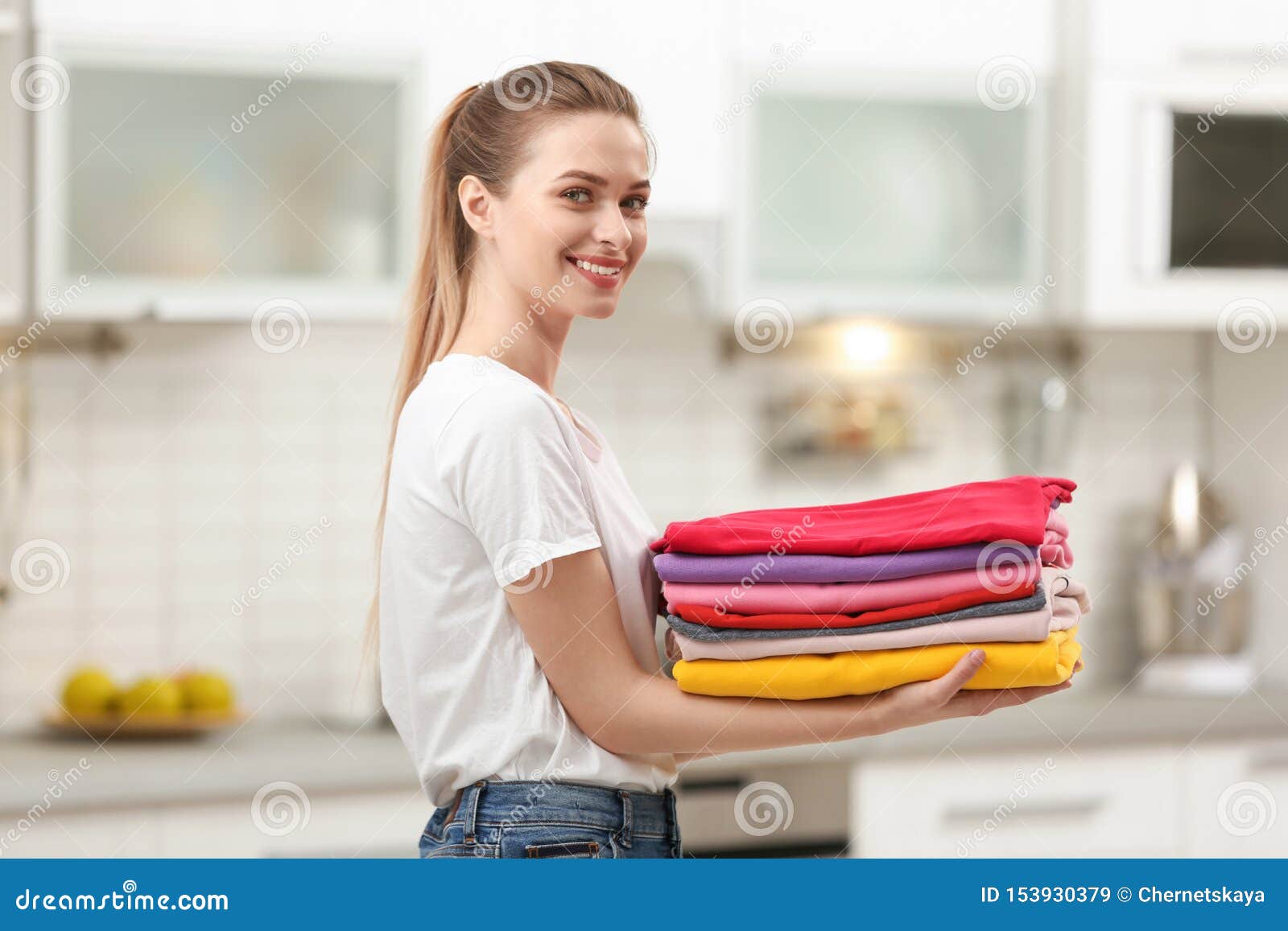Woman Holding Folded Clean Clothes in Kitchen Stock Image - Image of ...
