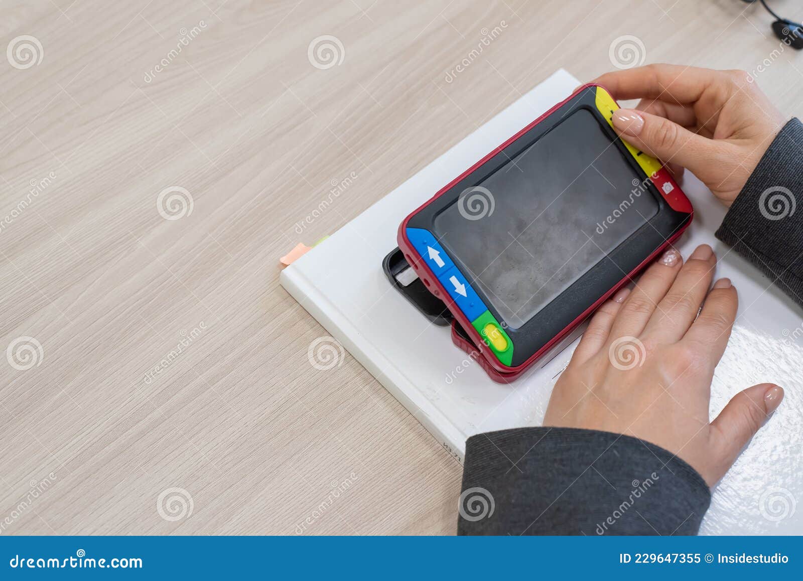 The Woman is Holding a Reading Device for the Visually Impaired ...