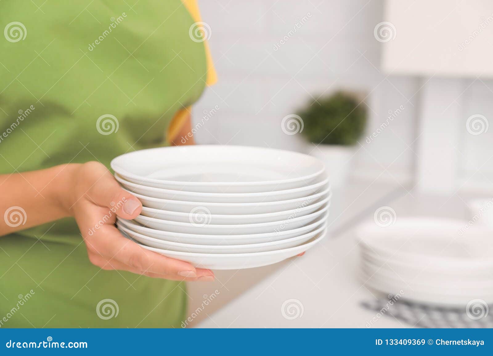 Woman Holding Stack of Clean Dishes in Kitchen, Closeup. Stock Image ...