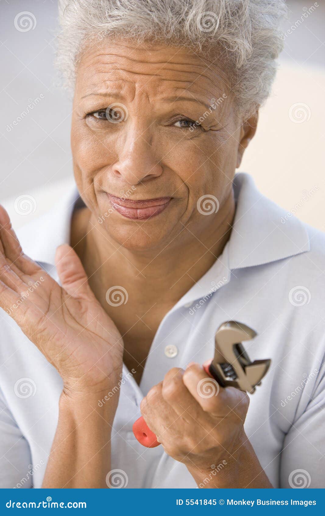 Woman Holding Wrench Looking Unsure Stock Image - Image of woman ...