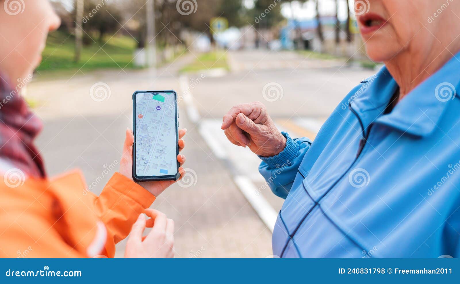 A Woman Holds a Smartphone with an Online Map and Shows the Way To an ... A Woman Holds a Smartphone with an Online Map and Shows the Way To an ...