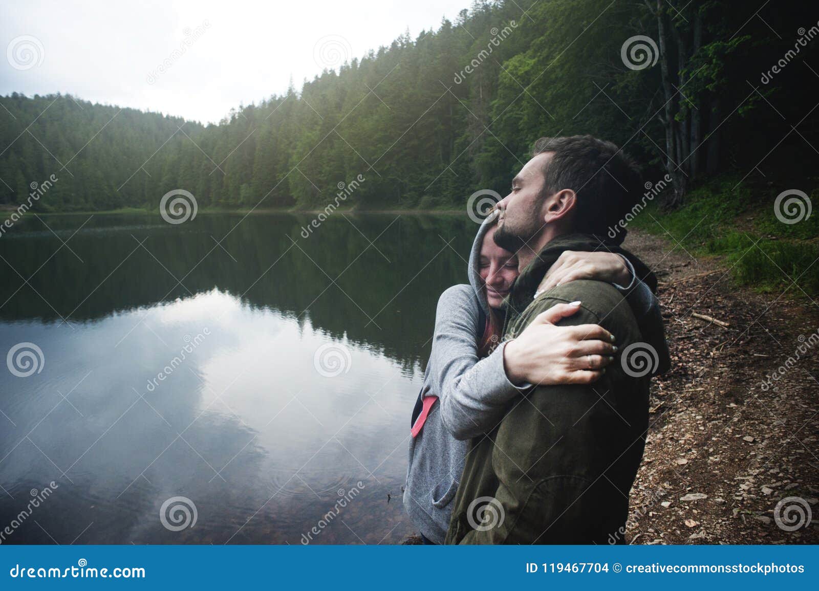 Woman Hugging Man Standing Beside Body Of Water Picture. Image: 119467704