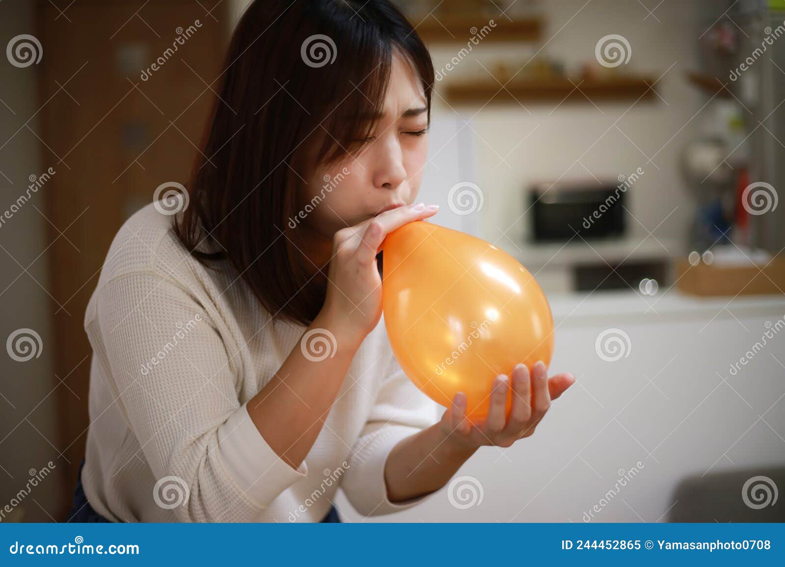 Woman inflating a balloon stock image. Image of playing - 244452865