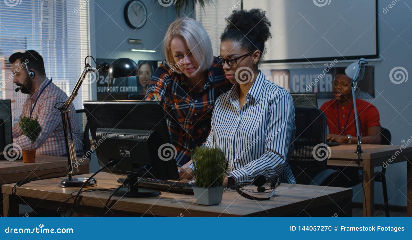 Woman Instructing Coworker at a Support Center Stock Photo - Image of ...