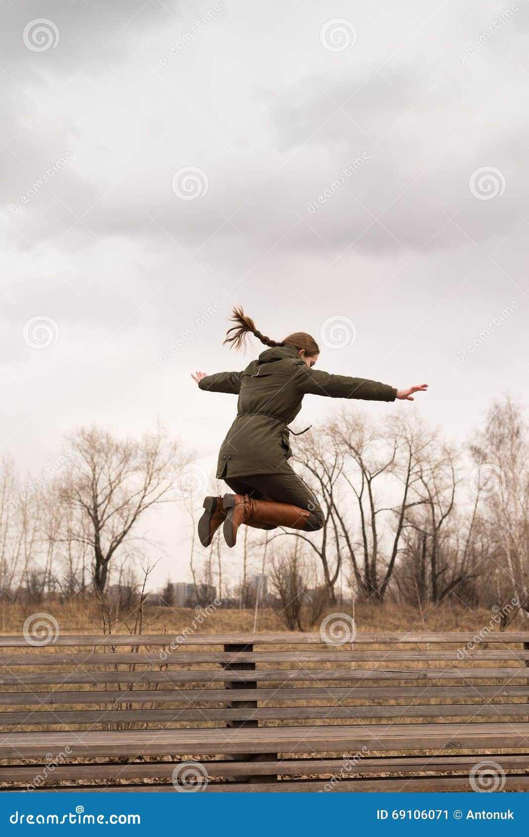 Woman Jumping from a Wooden Bench Stock Image - Image of cloudy ...
