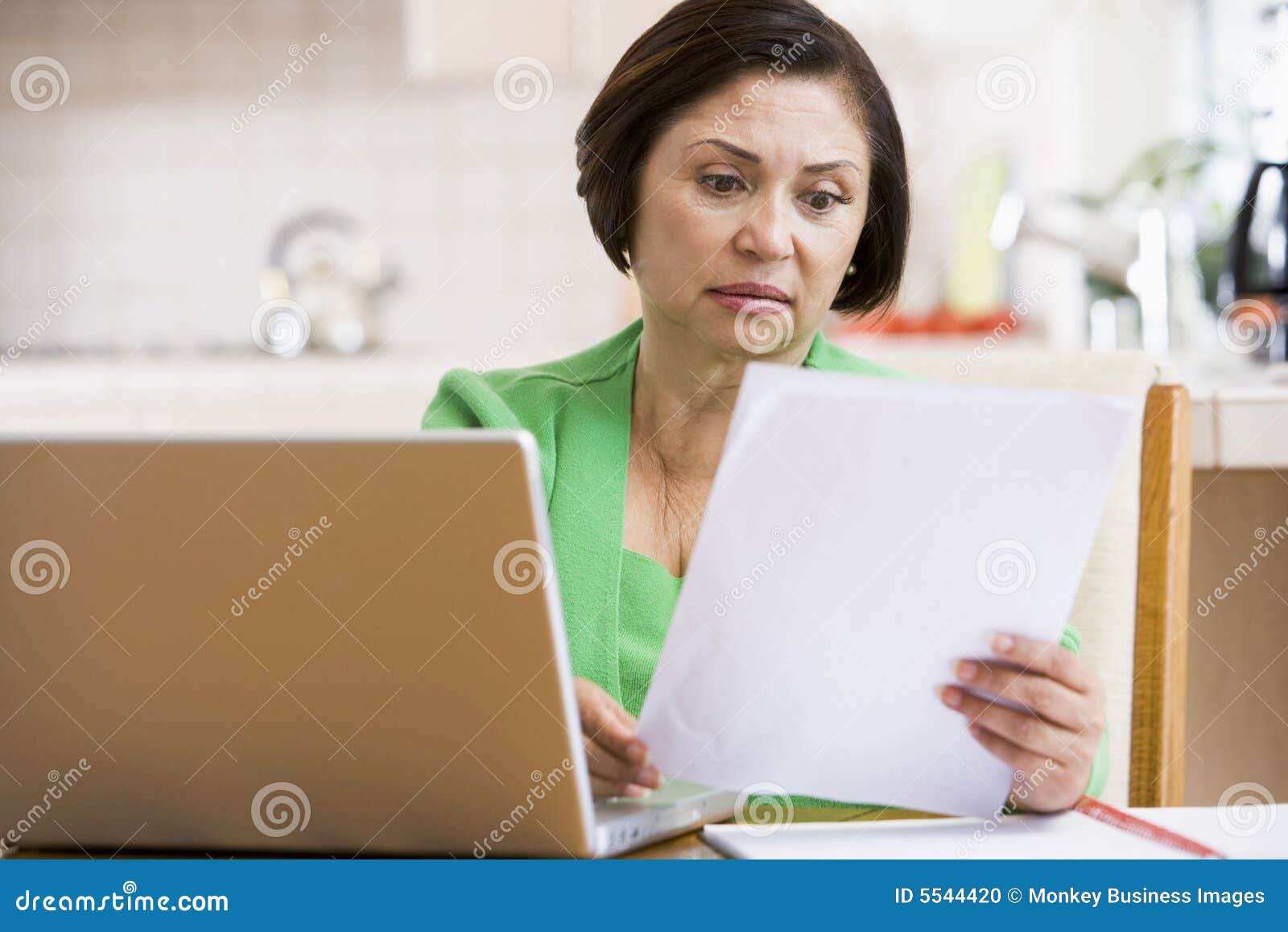 Woman in Kitchen with Laptop and Paperwork Stock Photo - Image of ...