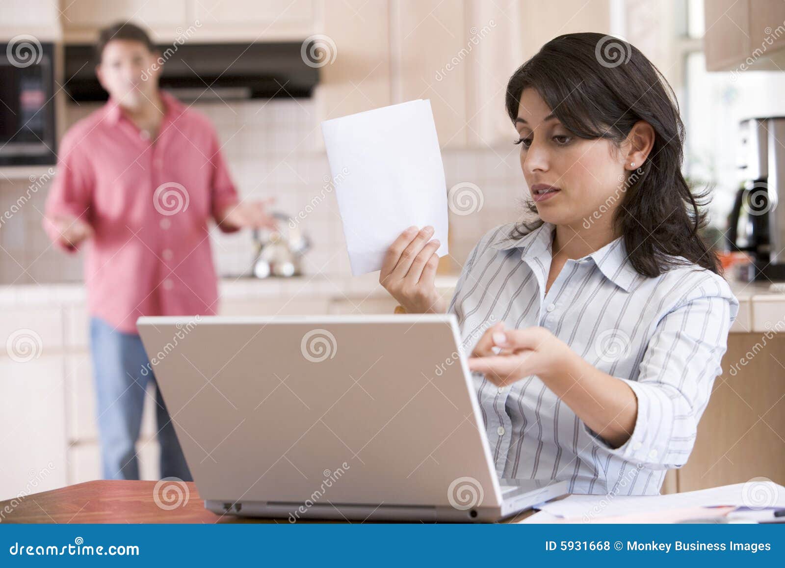 Woman in Kitchen with Paperwork Using Laptop Stock Photo - Image of ...