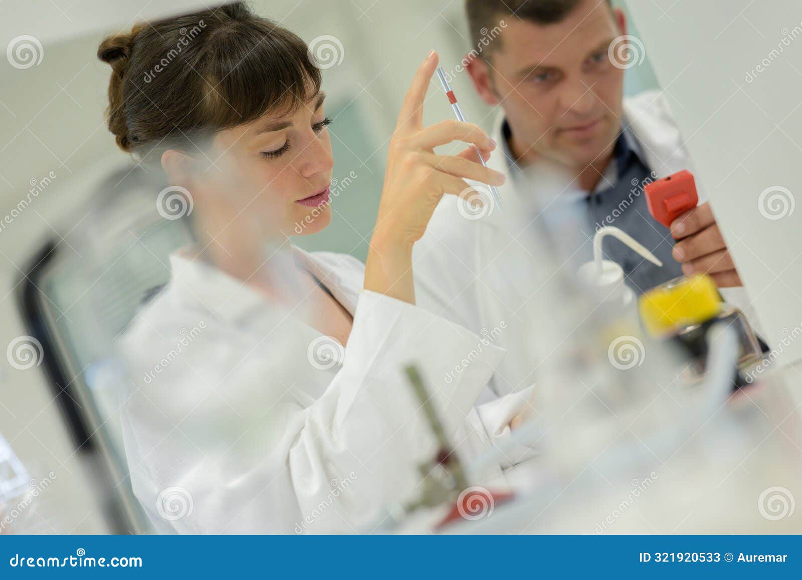 Woman in Lab and Colleague in Background Stock Image - Image of young ...