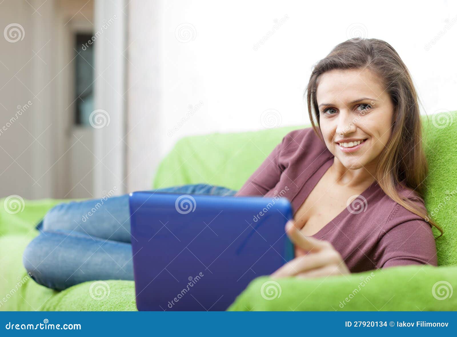 Woman with laptop on sofa stock photo. Image of internet - 27920134