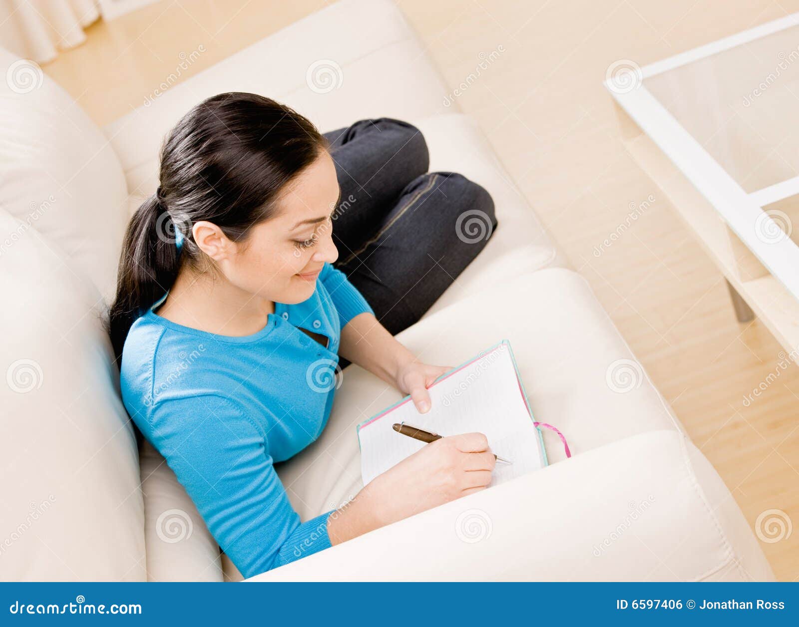 Woman Laying on Sofa in Livingroom Writing Stock Photo - Image of ...