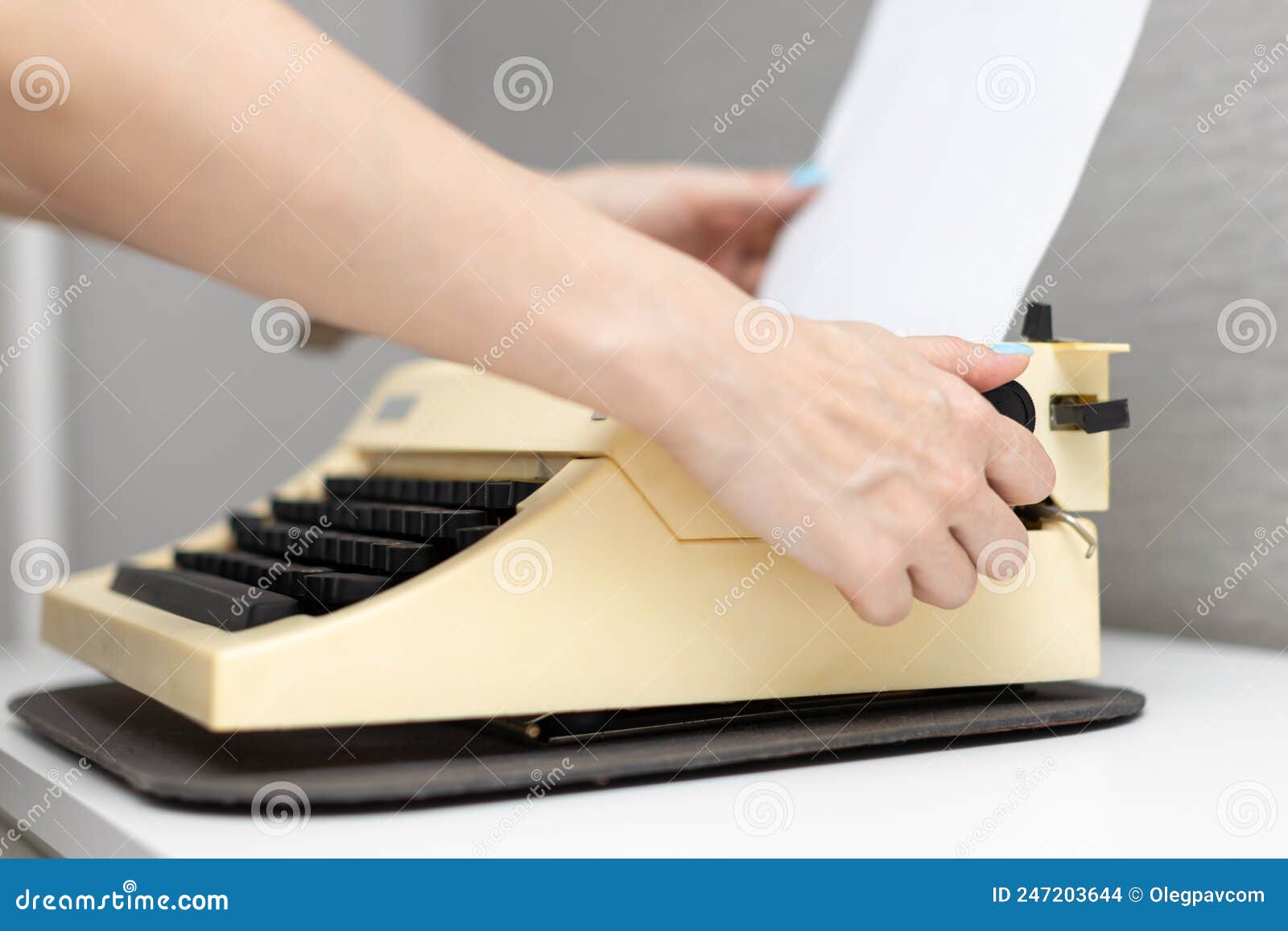 A Woman is Loading Paper into a Typewriter while Turning the Roller ...