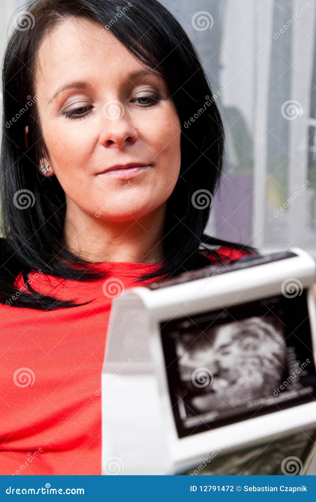 Woman looking at baby scan stock photo. Image of ultrasound - 12791472