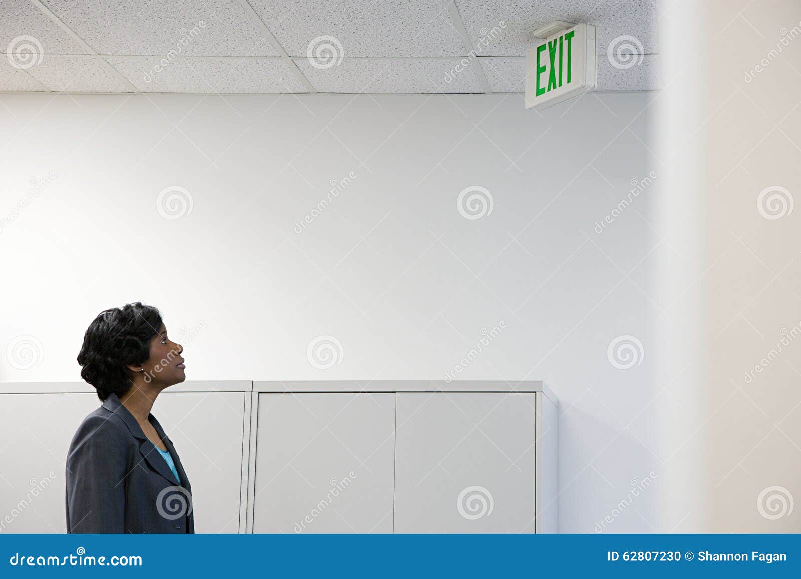 Woman looking at exit sign stock photo. Image of corridor - 62807230