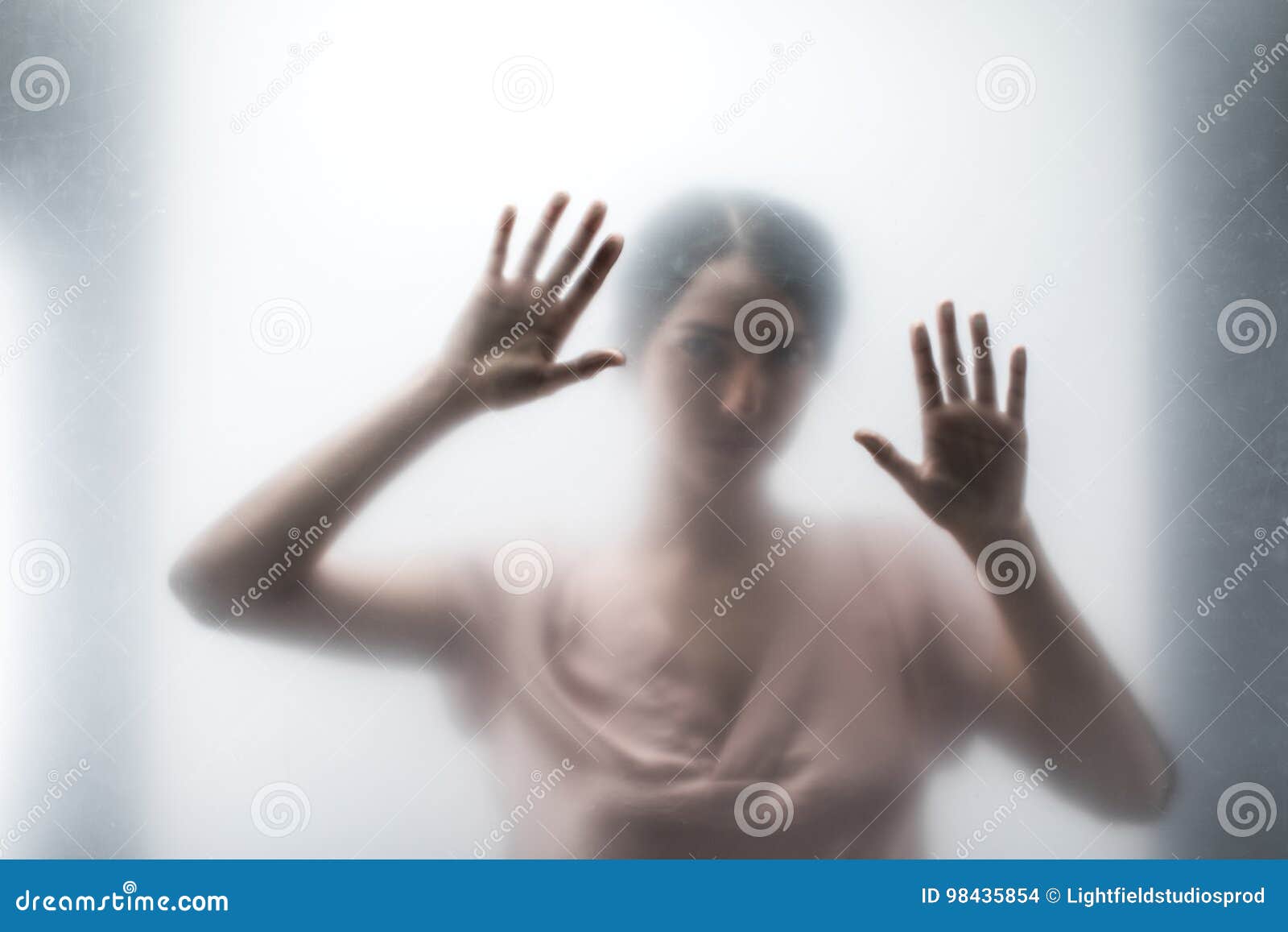 Woman Looking through the Glass and Touching it with Hands Stock Photo ...