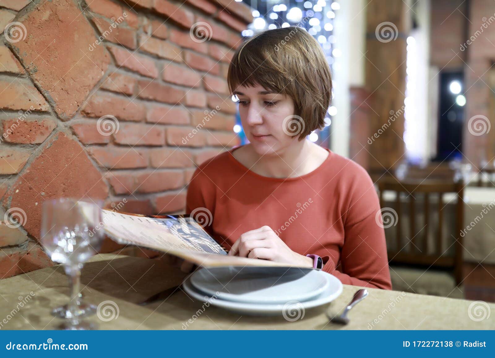 Woman looking at menu book stock photo. Image of order - 172272138