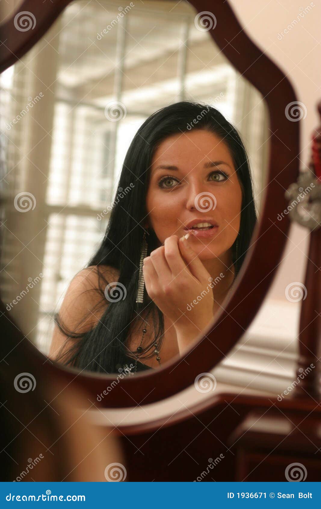 Woman looking in mirror stock image. Image of attractive - 1936671