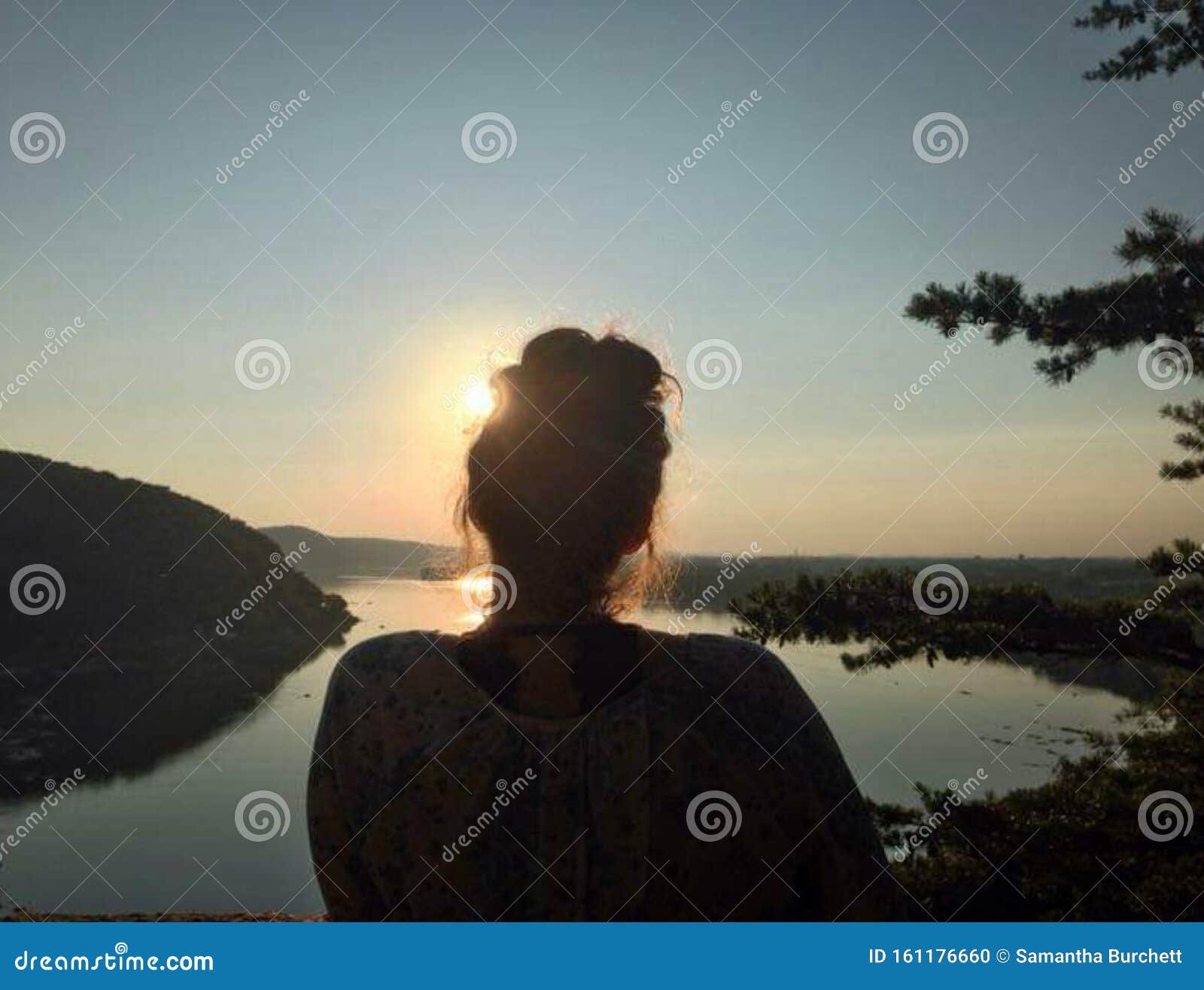 Woman Looking Over the Water Standing in the Mountains at Sunset ...
