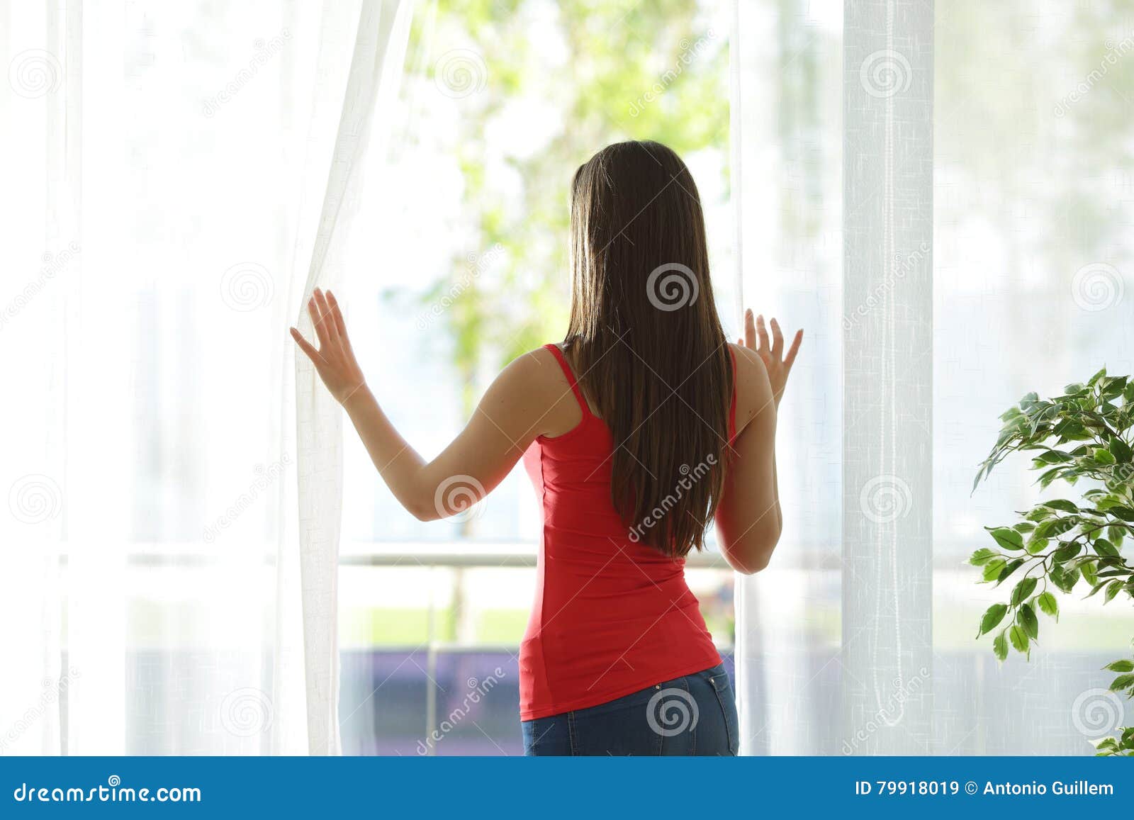 Woman Looking through a Window at Home Stock Image - Image of ...