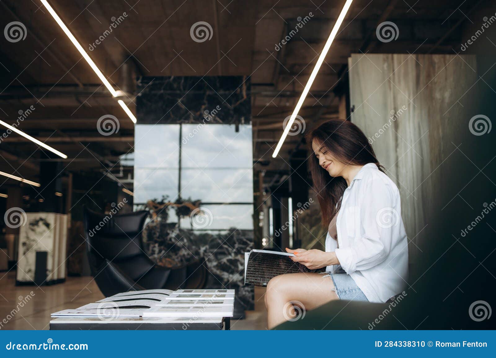 A Woman Looks at a Catalog of Goods in a Hardware Store Stock Photo ...