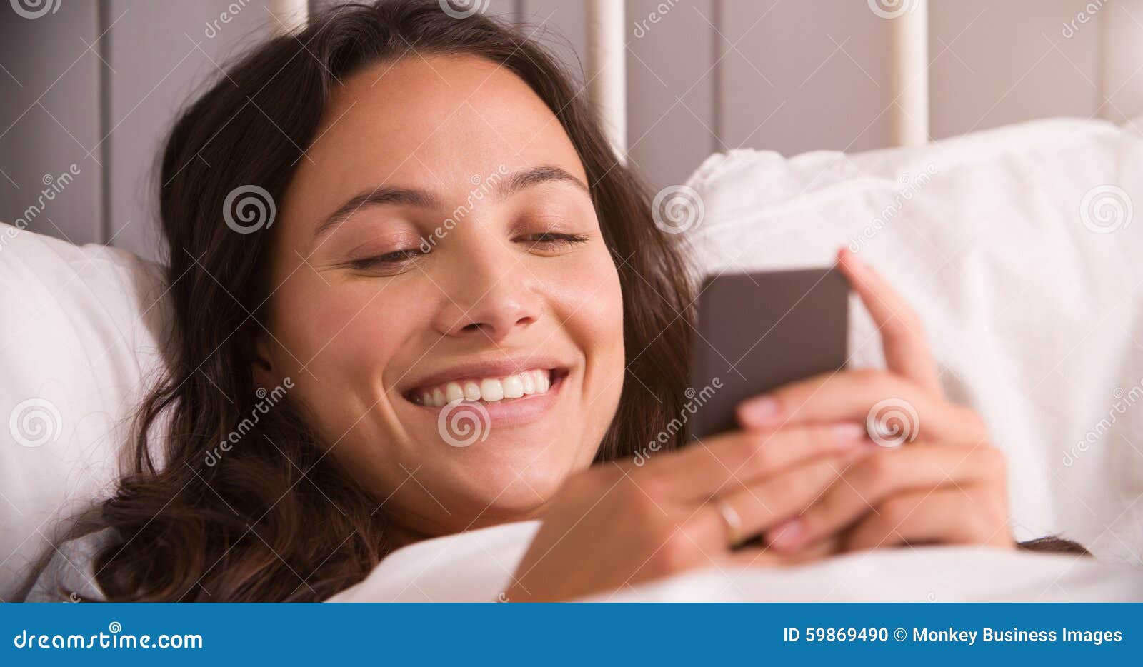Woman Lying in Bed Checking Messages on Mobile Phone Stock Photo ...