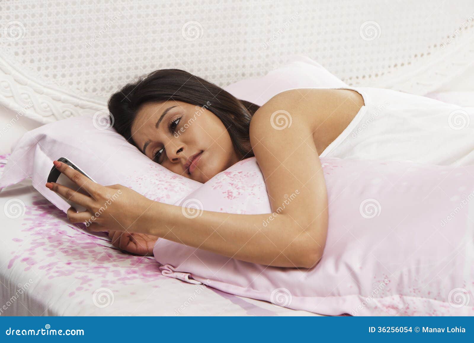 Woman Lying on the Bed and Holding a Mobile Phone Stock Photo - Image ...