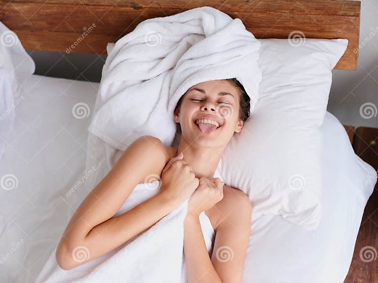 Woman Lying On Bed After Shower With Wet Hair With Towel On Her Head In
