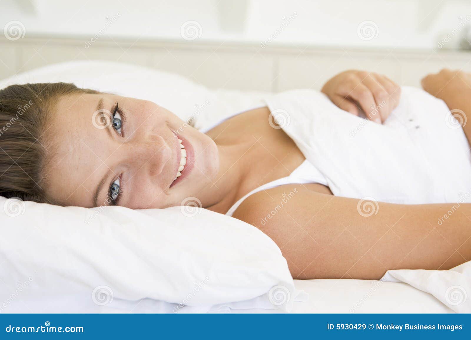 Woman lying in bed smiling stock image. Image of bedroom - 5930429