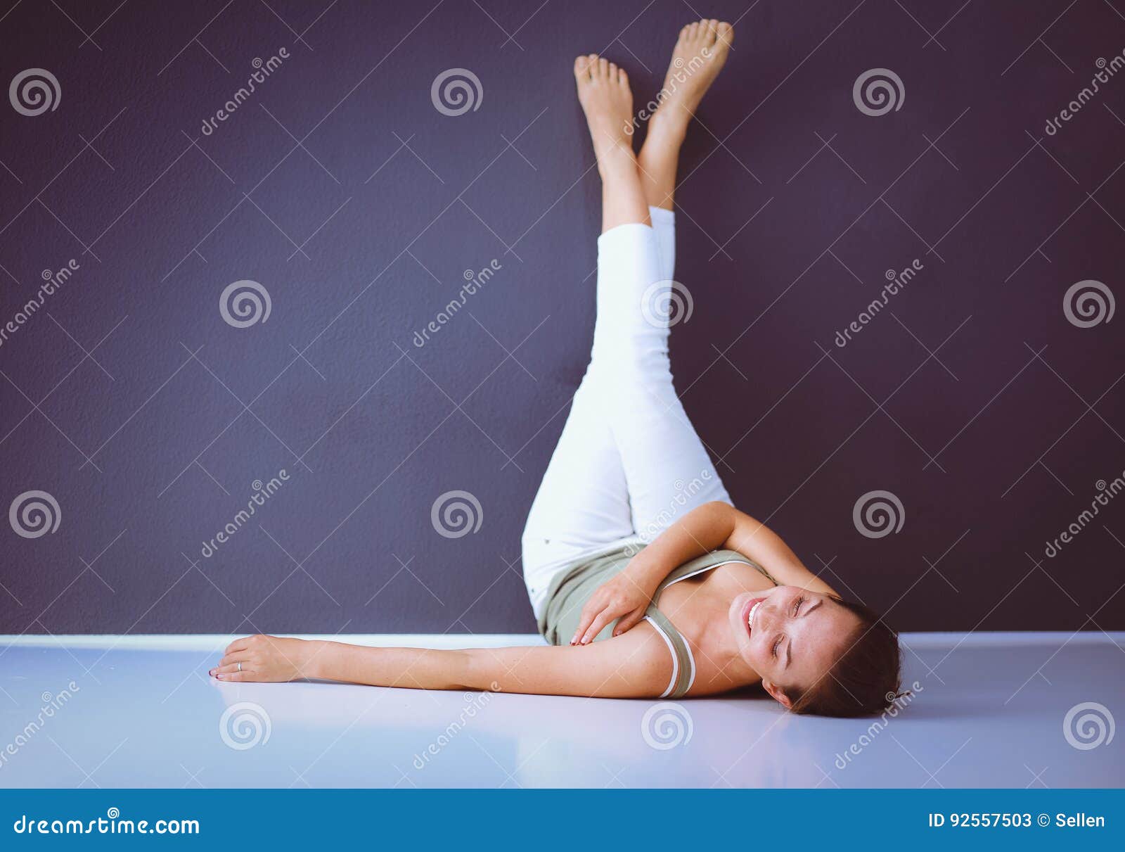 A Woman Lying on the Floor with Legs Up Stock Image - Image of holding ...