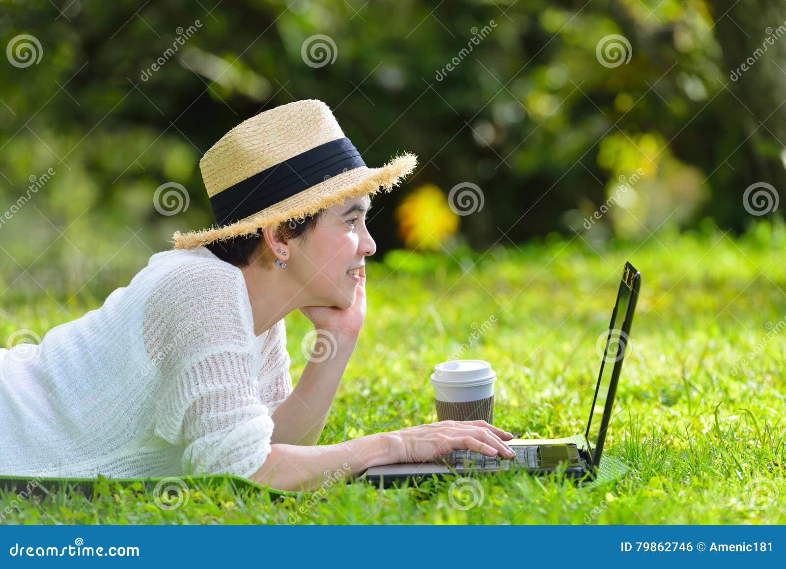 Woman Lying on Green Grass Using Laptop Computer in the Park Stock ...