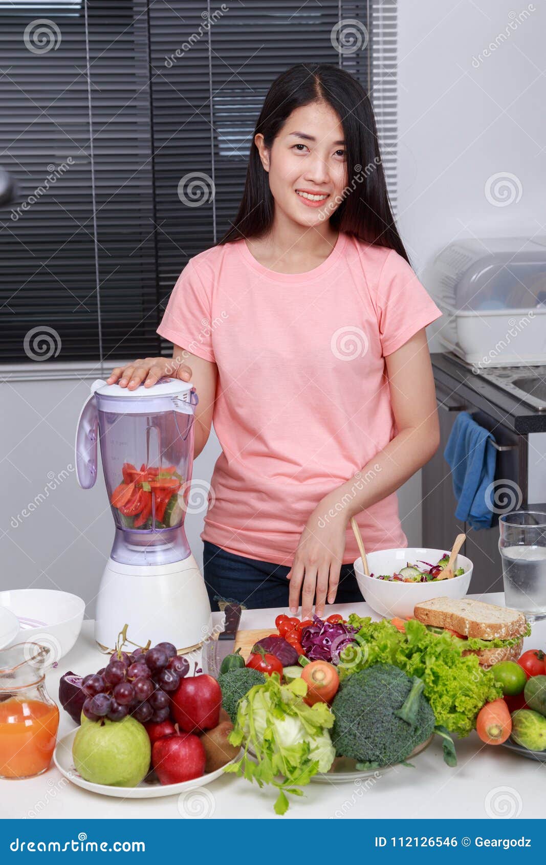 Woman Making Vegetable Smoothies with Blender in Kitchen Stock Photo ...