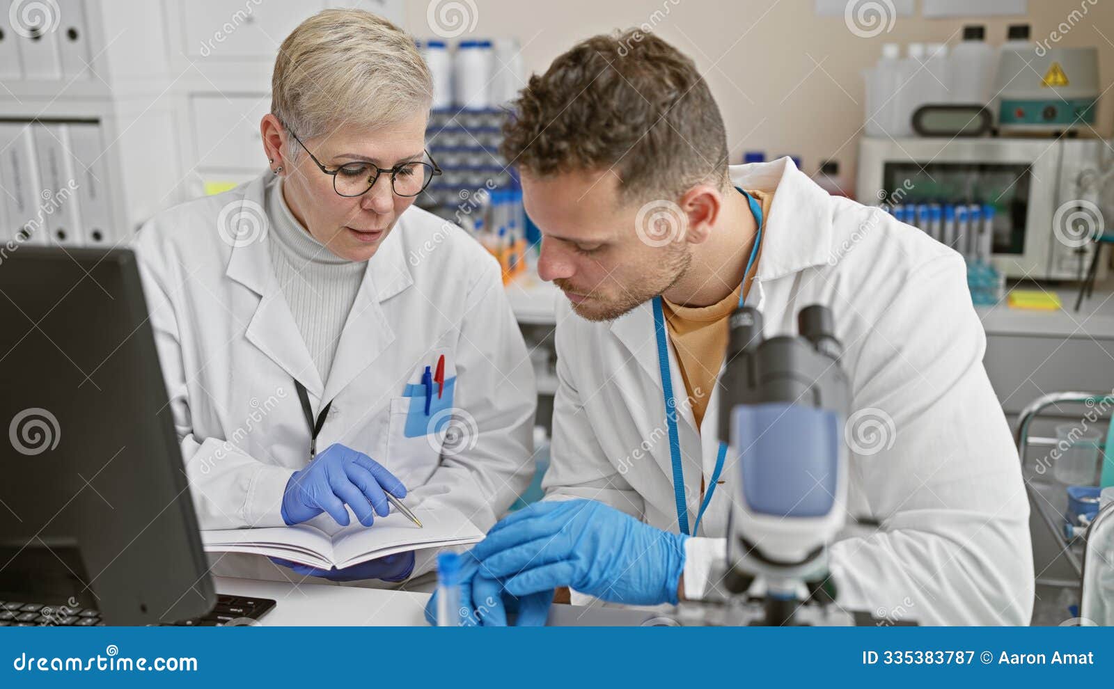 A Woman and Man, in Lab Coats, Analyze Data in a Science Laboratory ...